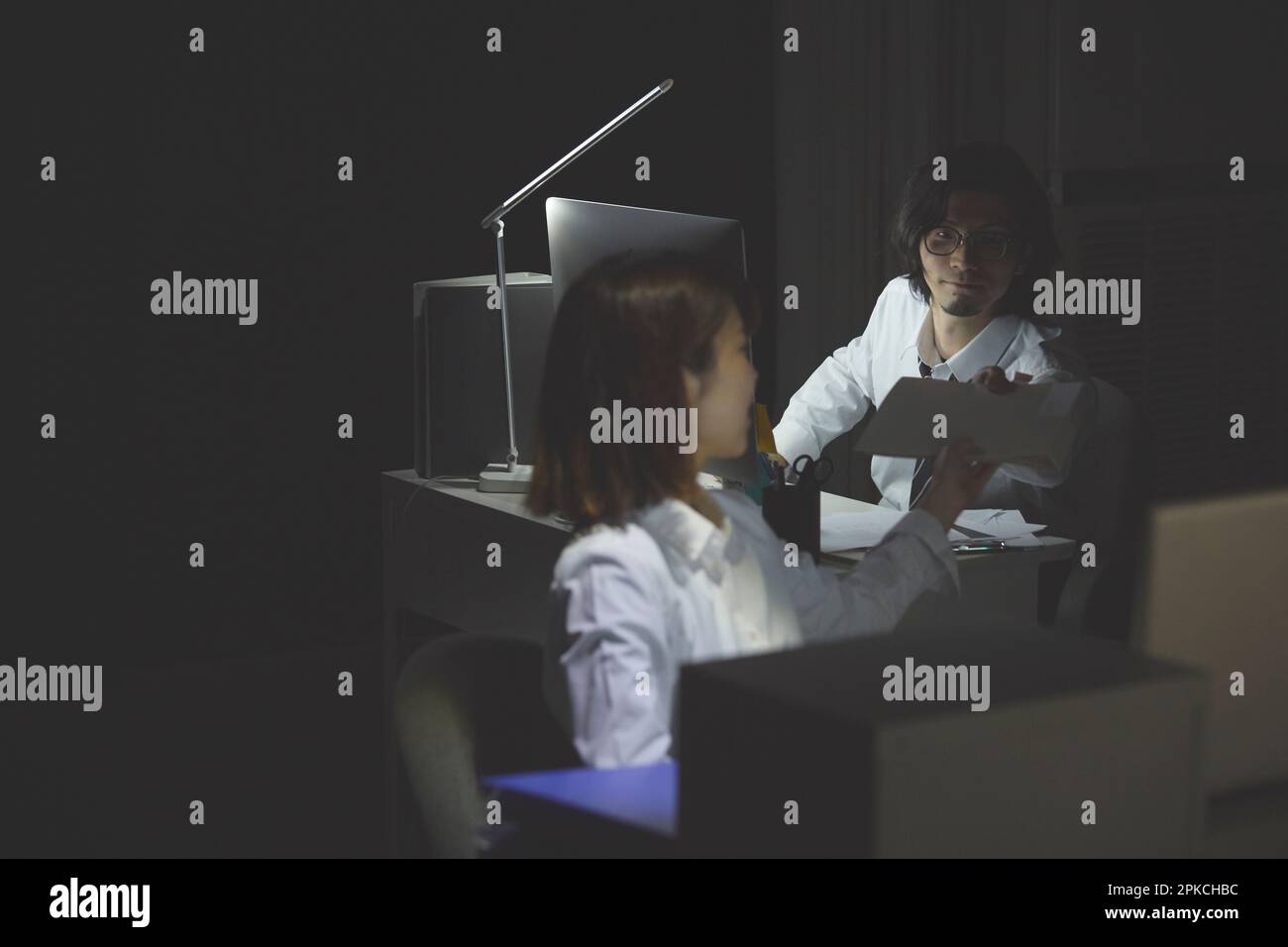 Woman and man working overtime in an office Stock Photo - Alamy