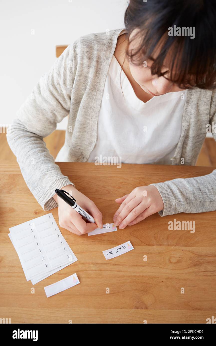 A woman writing her name on a name tag Stock Photo - Alamy