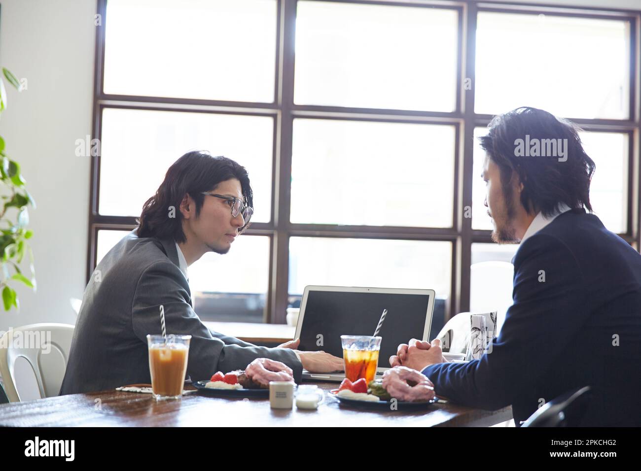 Two office workers discussing a proposal for a new menu item Stock ...