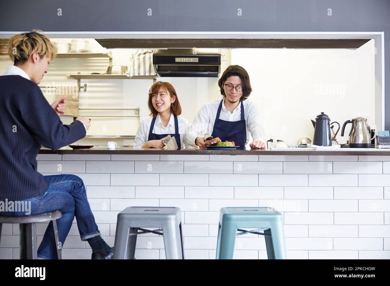 Cafe staff serving male customers over the counter Stock Photo - Alamy