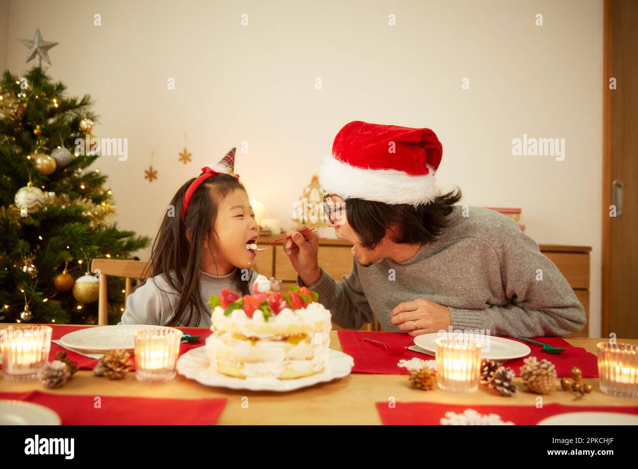 Parent and child eating Christmas cake Stock Photo - Alamy