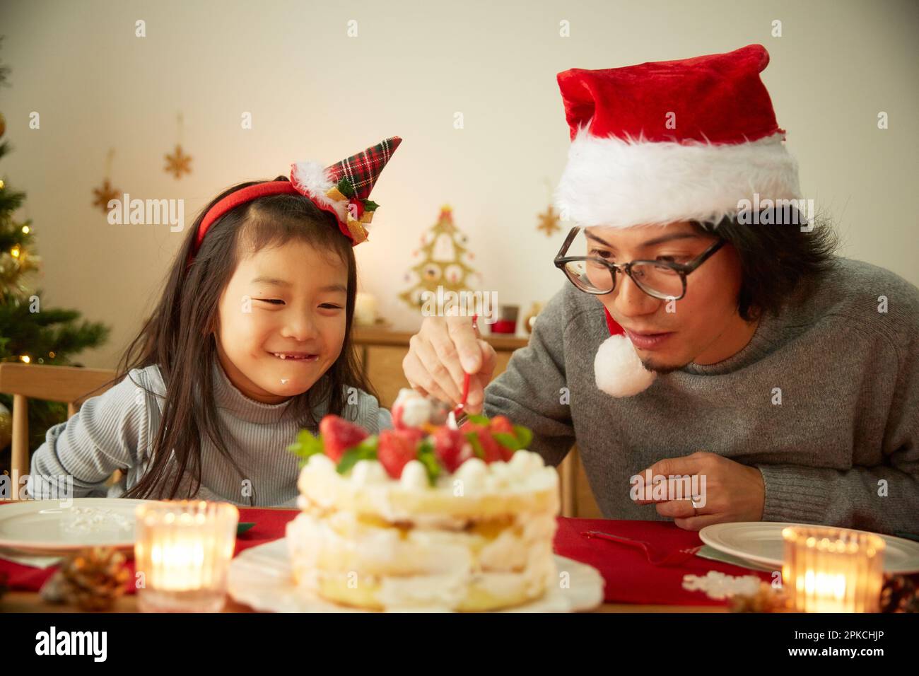 Parents and children trying to eat Christmas cake Stock Photo - Alamy