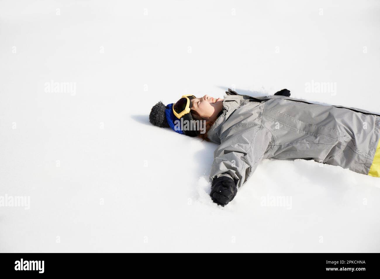 Woman lying on snow Stock Photo - Alamy