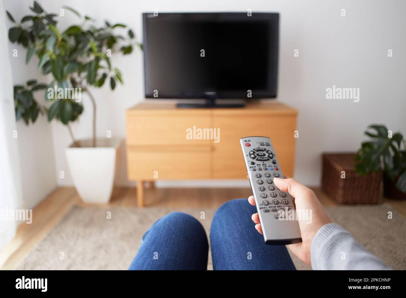 Hands operating the TV in the living room with the remote control Stock ...