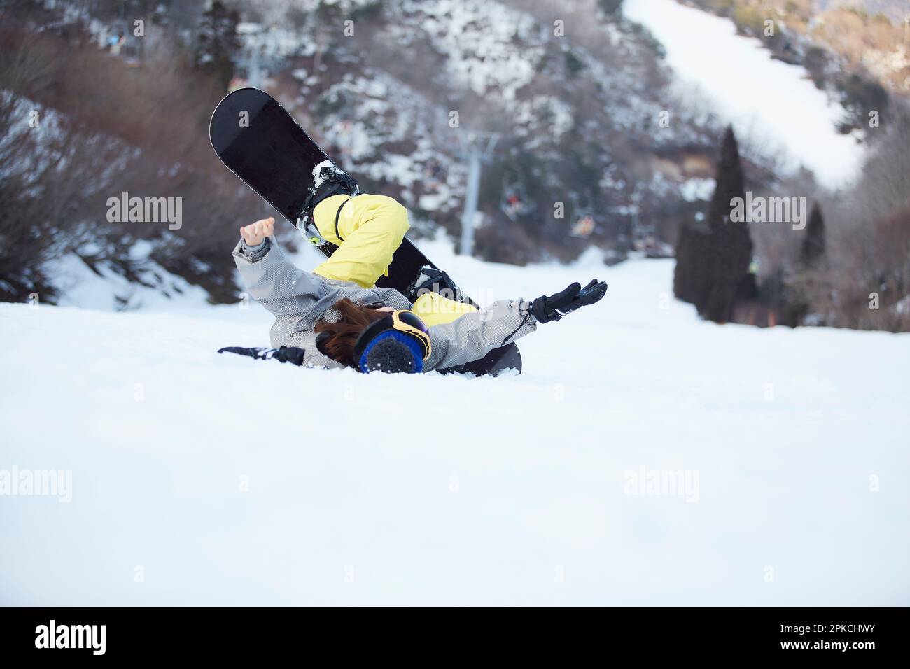 Woman falling down on a snowboard Stock Photo - Alamy