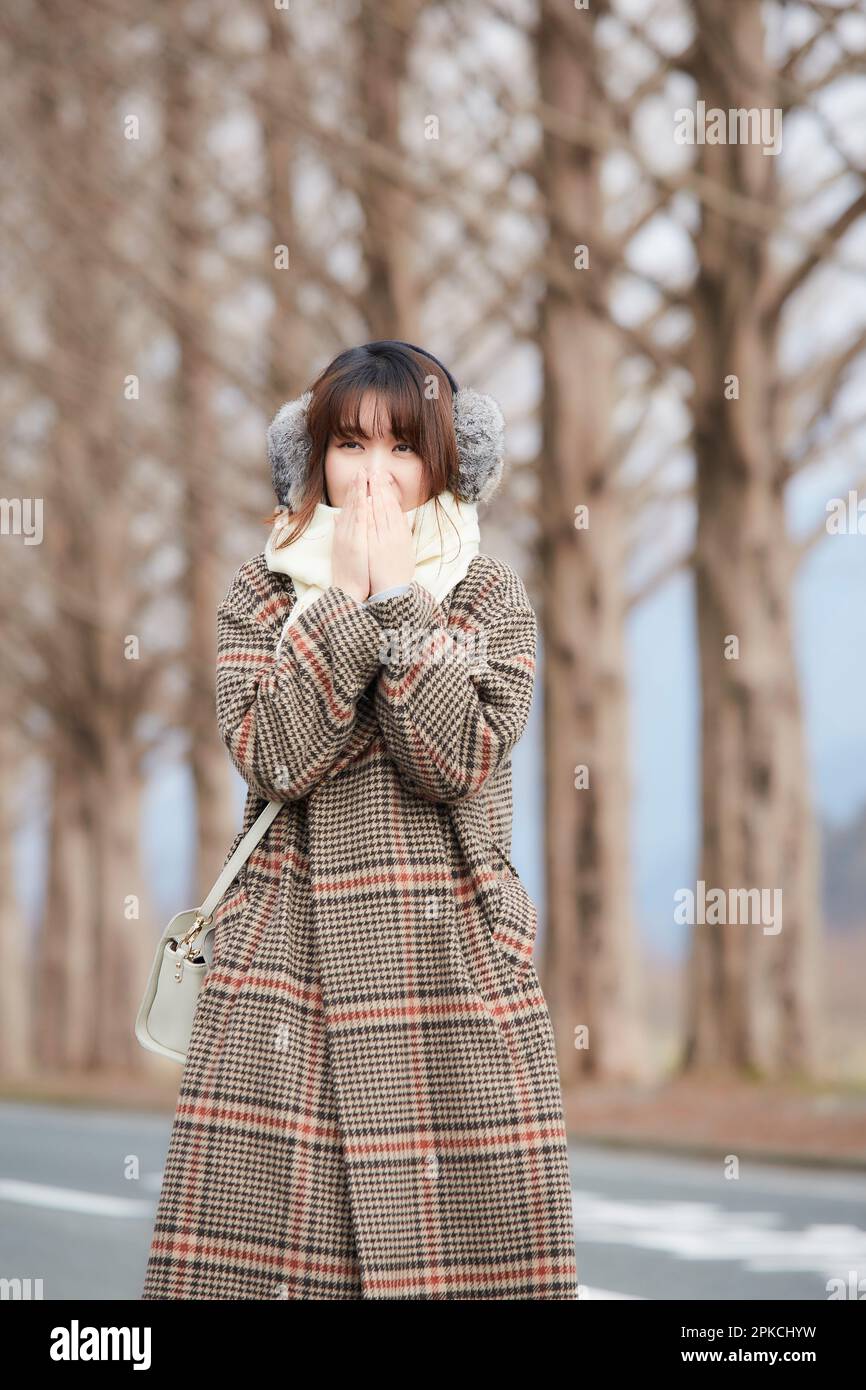 A woman looking cold on a country road Stock Photo - Alamy