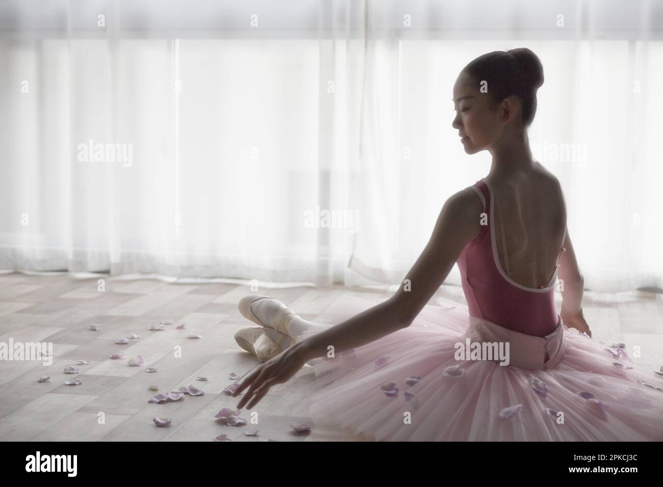 Ballerina and petals sitting on the floor Stock Photo - Alamy