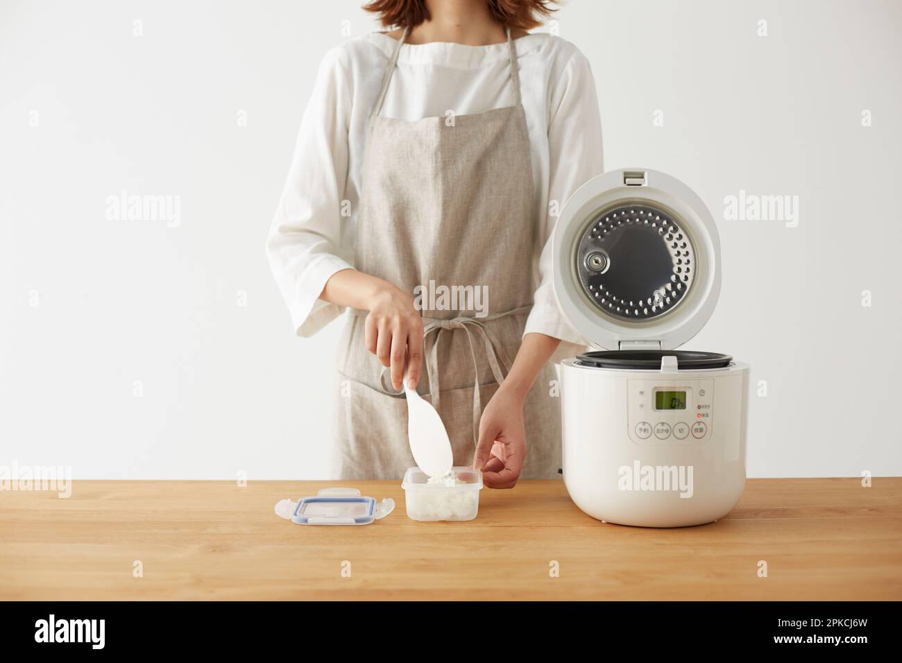 Woman packing white rice into Tupperware Stock Photo - Alamy