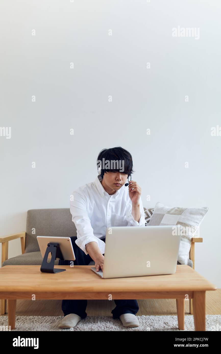 Man operating computer and tablet with intercom in living room Stock ...