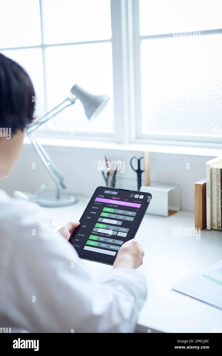 A man placing a stock order with his tablet at his desk Stock Photo - Alamy