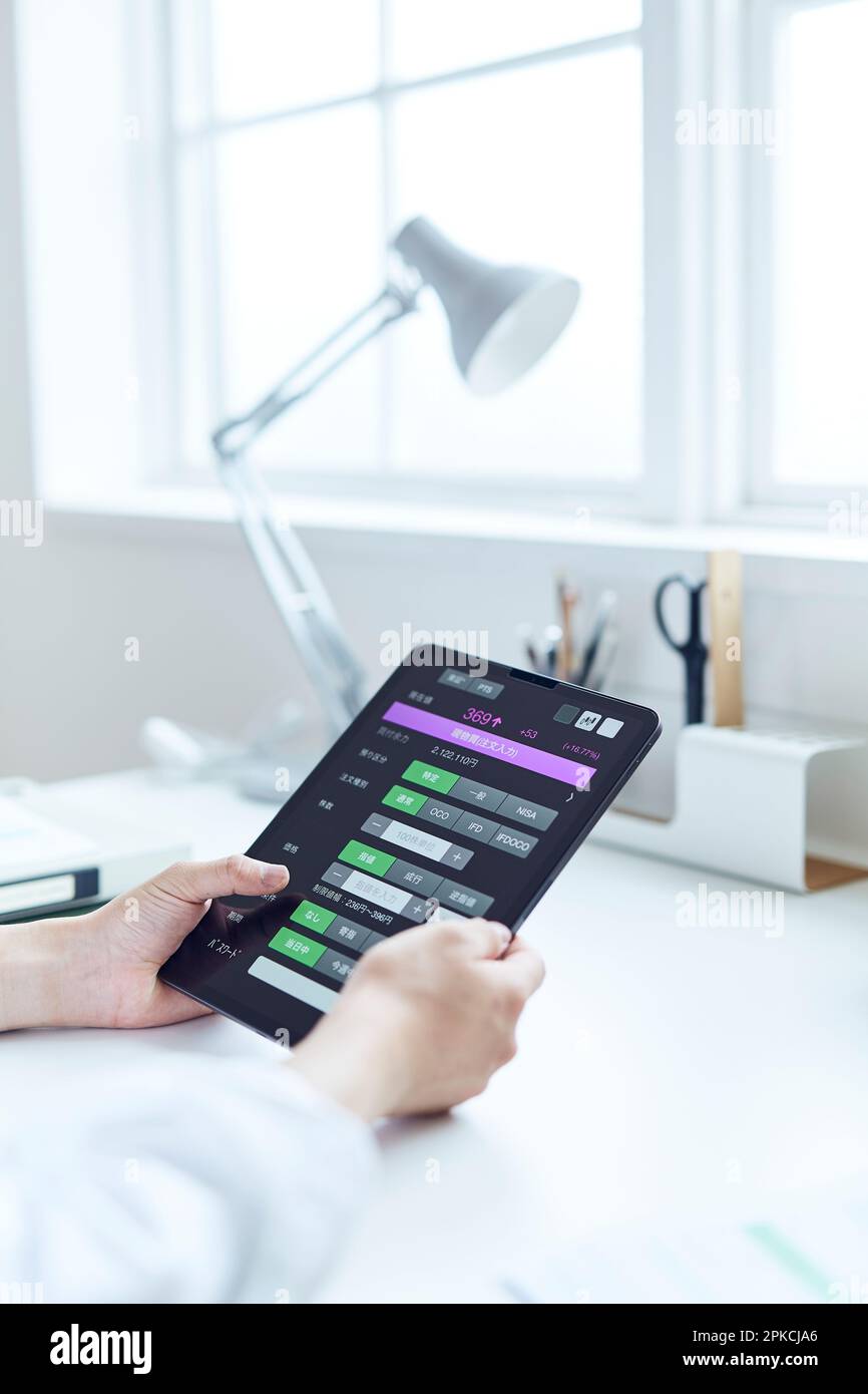 Hand placing a stock order with a tablet at his desk Stock Photo - Alamy