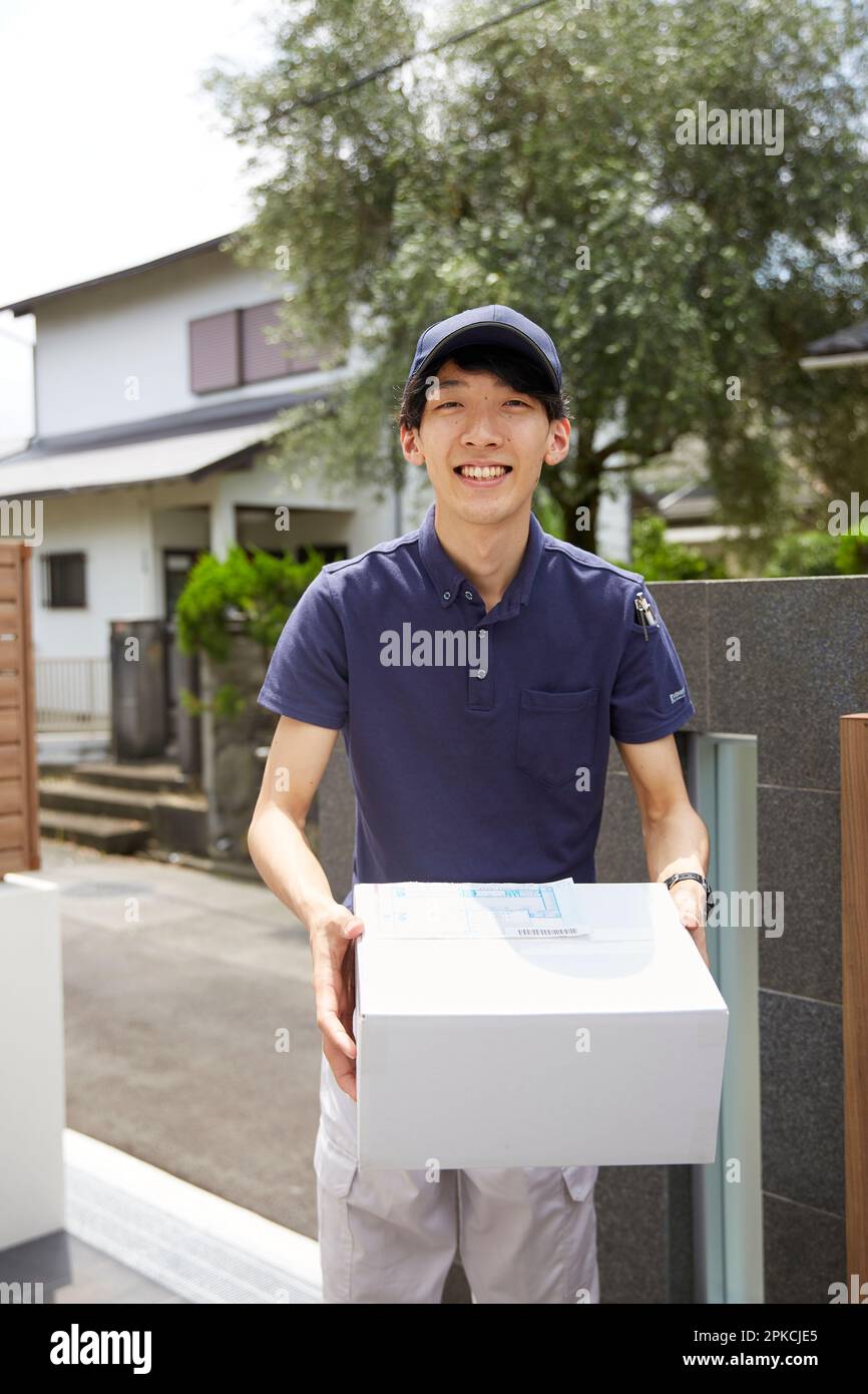 Delivery man carrying a package Stock Photo - Alamy