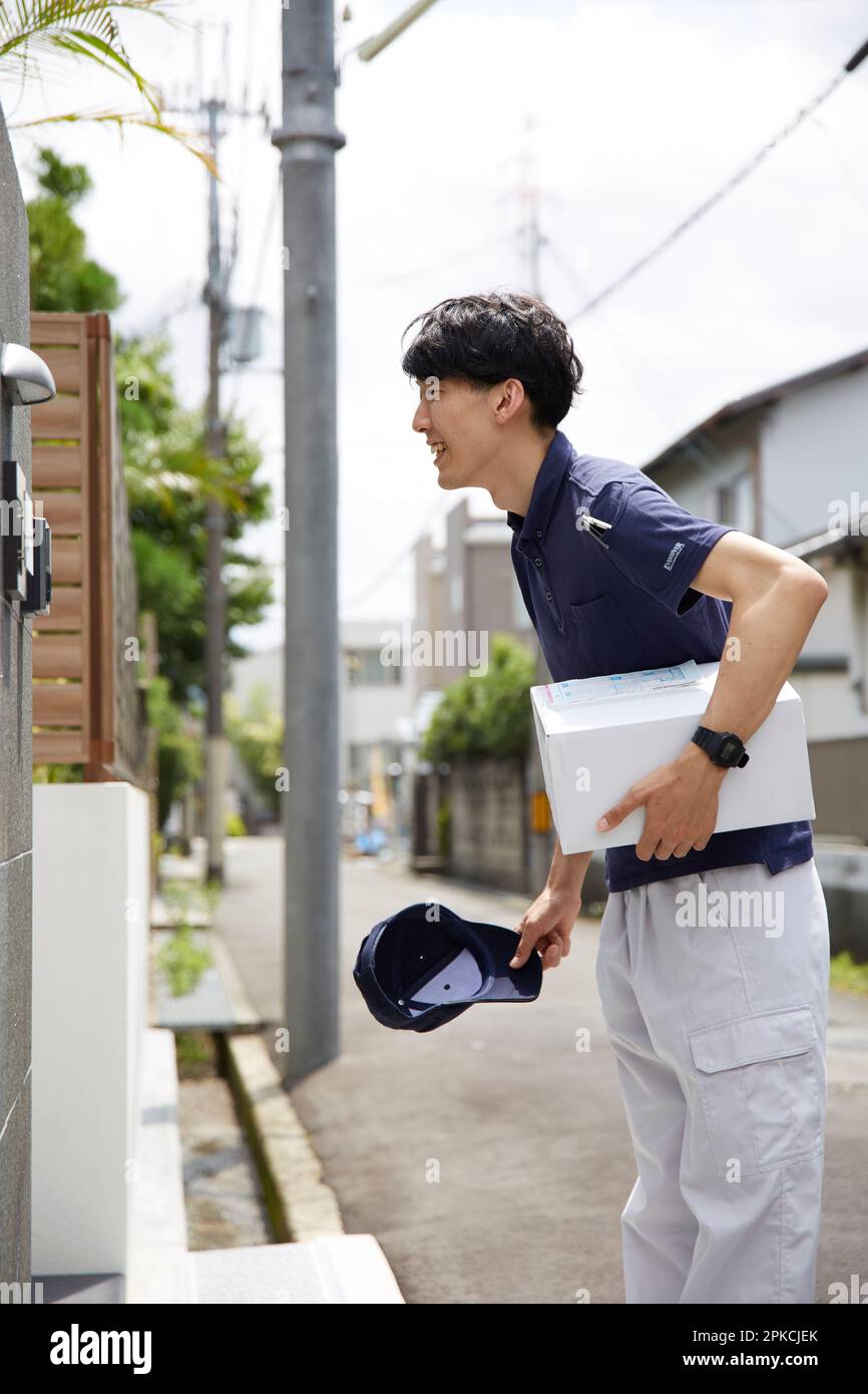 Delivery man carrying a package Stock Photo - Alamy