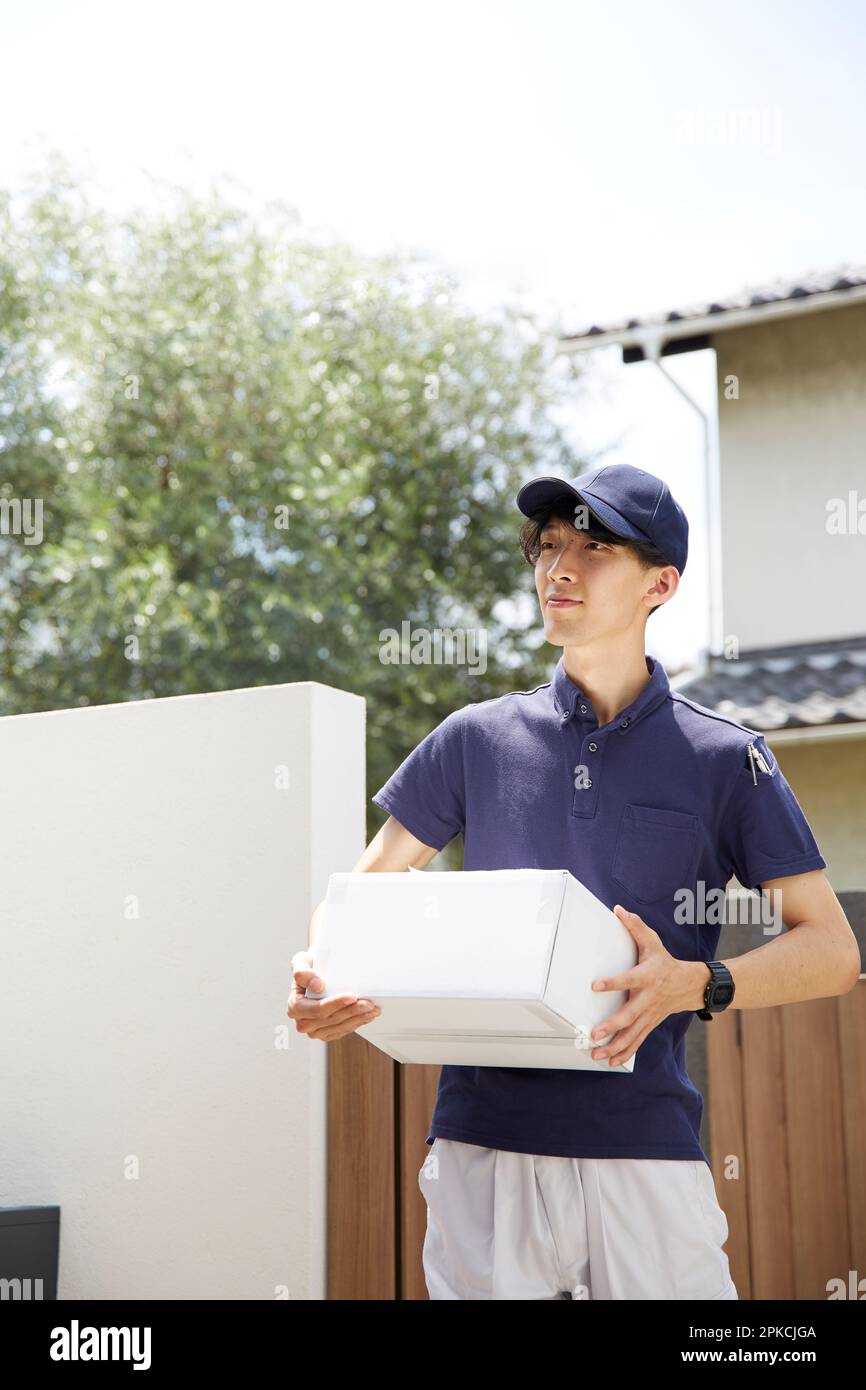 Delivery man carrying a package Stock Photo - Alamy