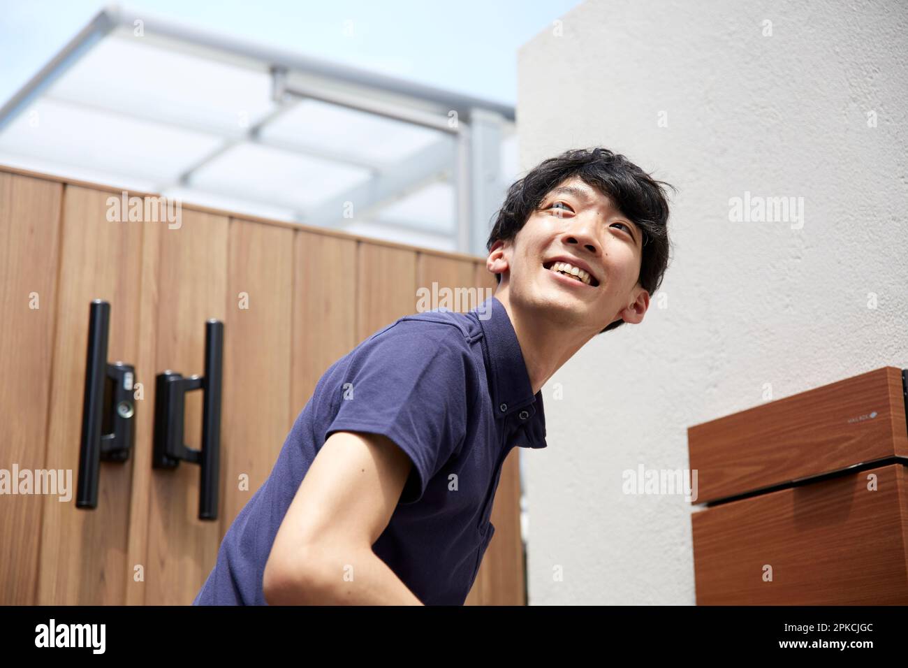 Delivery man putting a package in a delivery box Stock Photo - Alamy