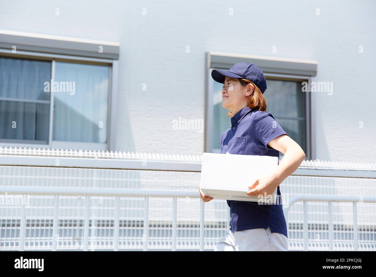Female courier carrying a package Stock Photo - Alamy