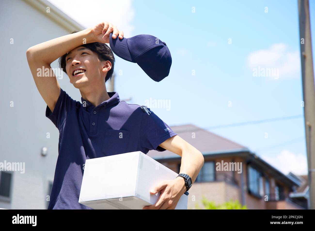 Male delivery man carrying a package Stock Photo - Alamy