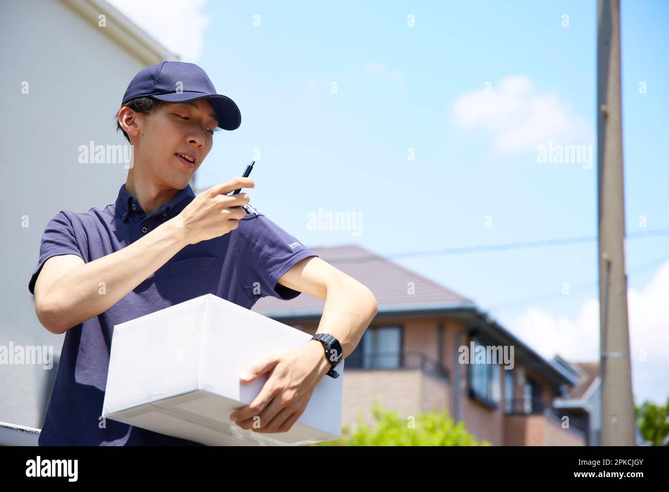 Male delivery man carrying a package Stock Photo - Alamy