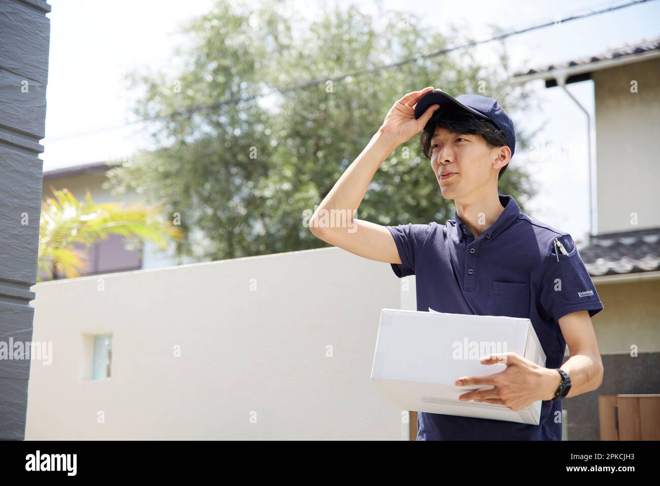 Delivery man carrying a package Stock Photo - Alamy