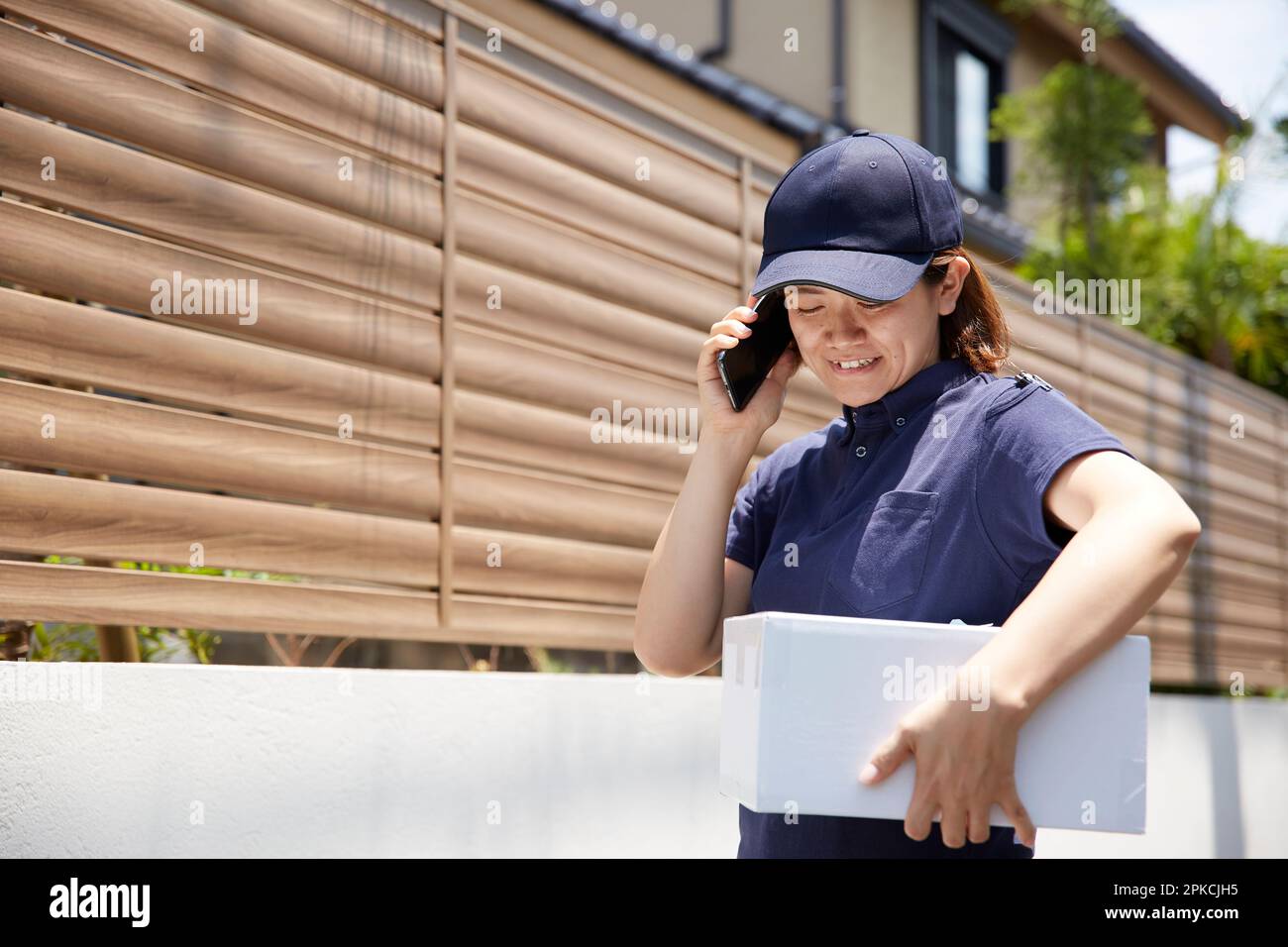 Delivery woman carrying a package Stock Photo - Alamy