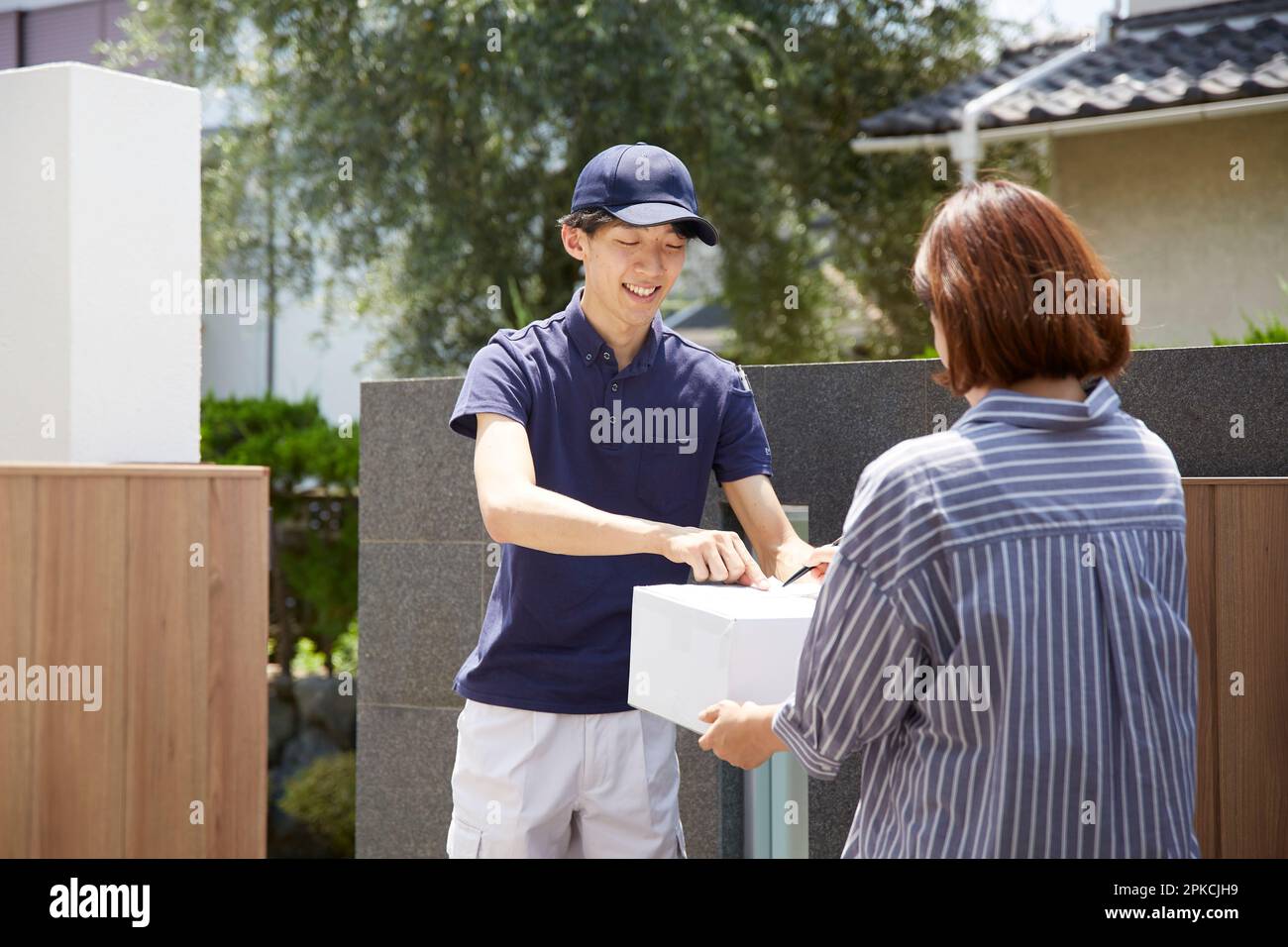 Delivery man delivering packages Stock Photo - Alamy