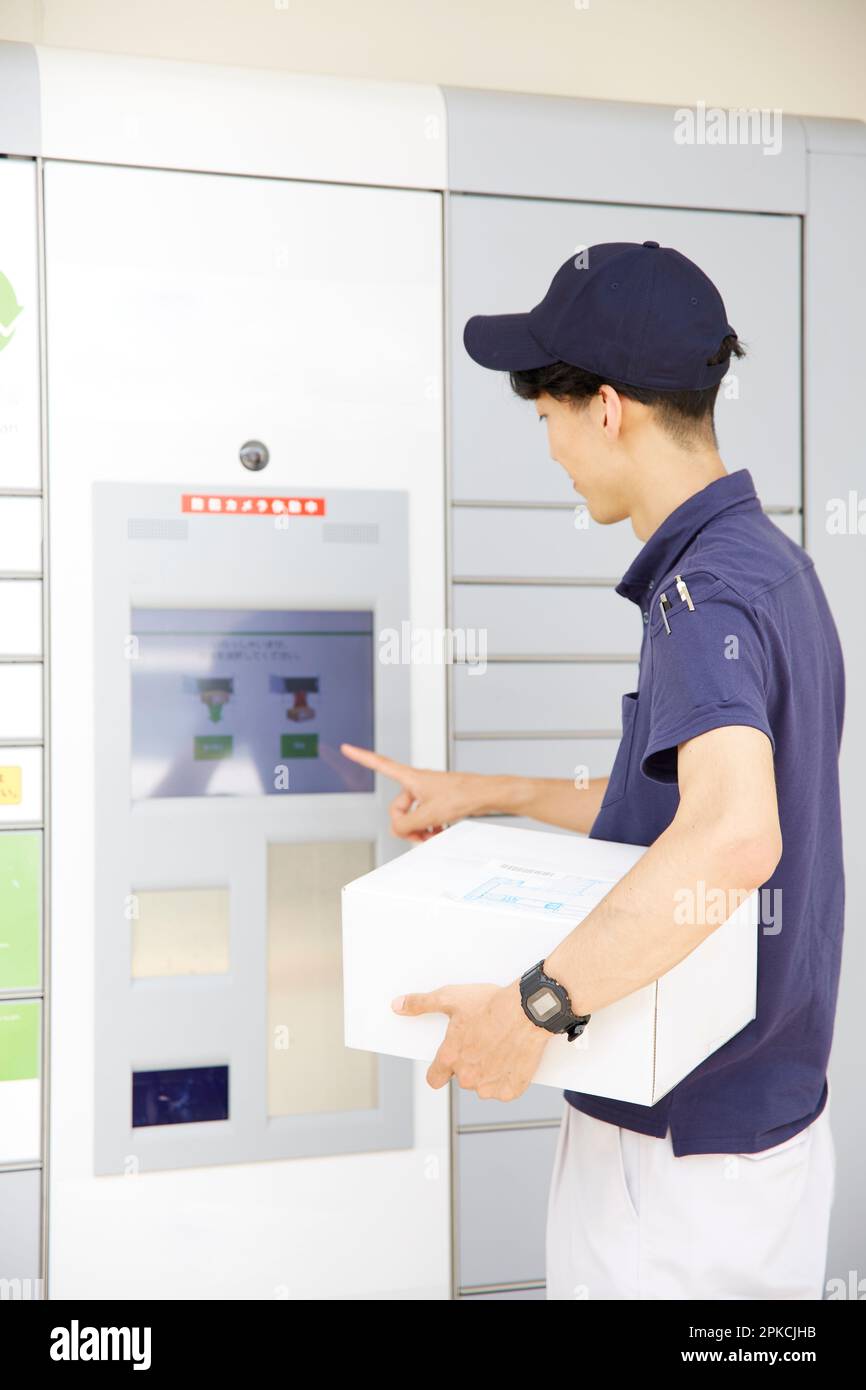 Delivery man putting a package in a delivery box in the city Stock ...