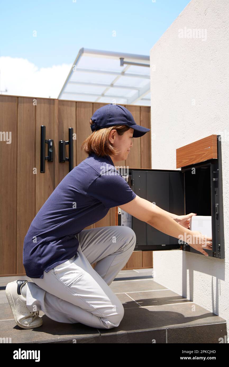 Female courier carrying a package Stock Photo - Alamy
