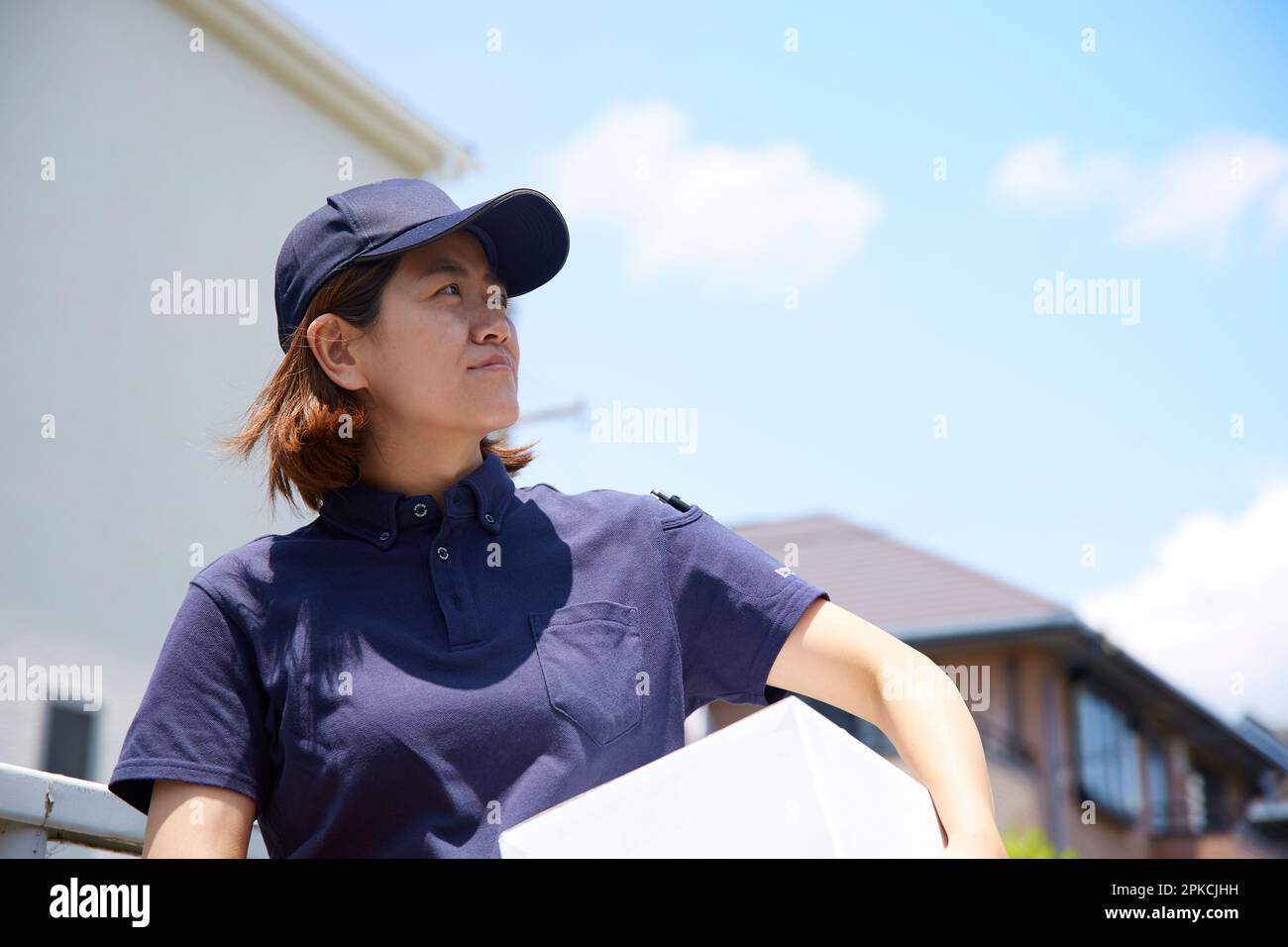 Delivery woman carrying a package Stock Photo - Alamy