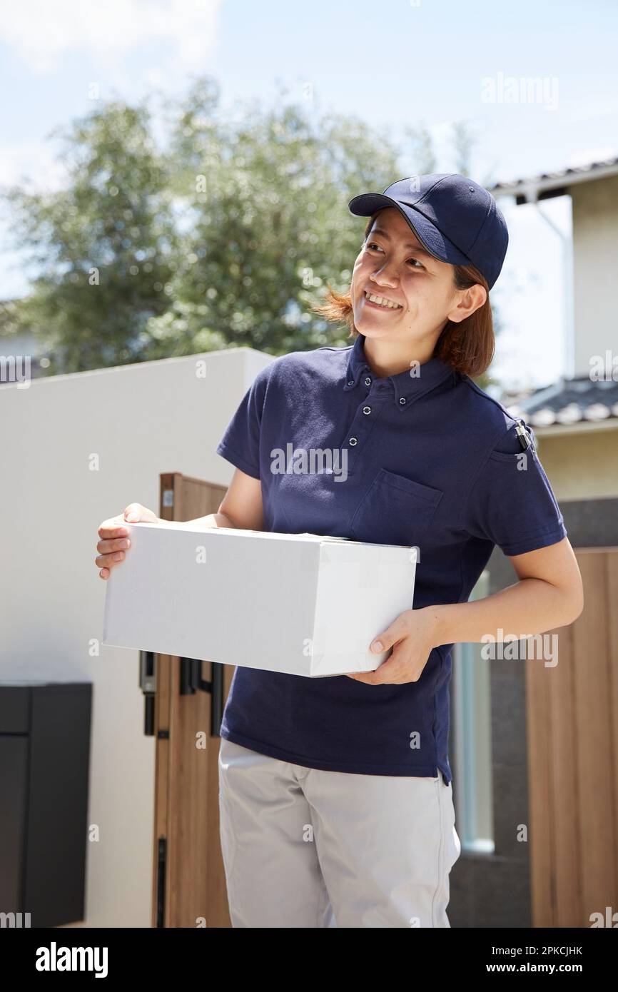 Delivery woman carrying a package Stock Photo - Alamy