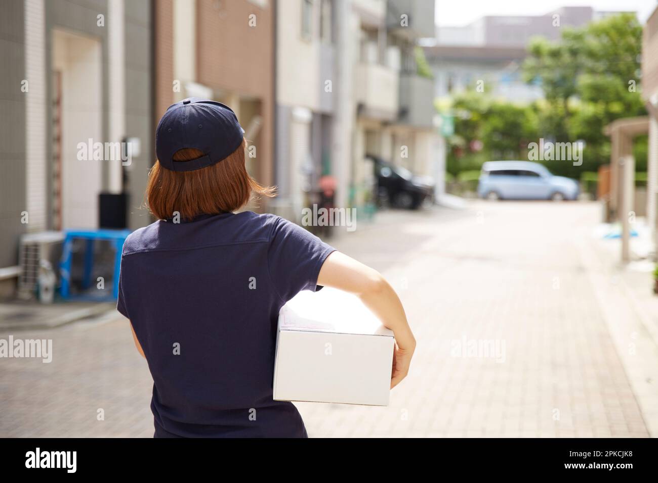 Female courier carrying a package Stock Photo - Alamy