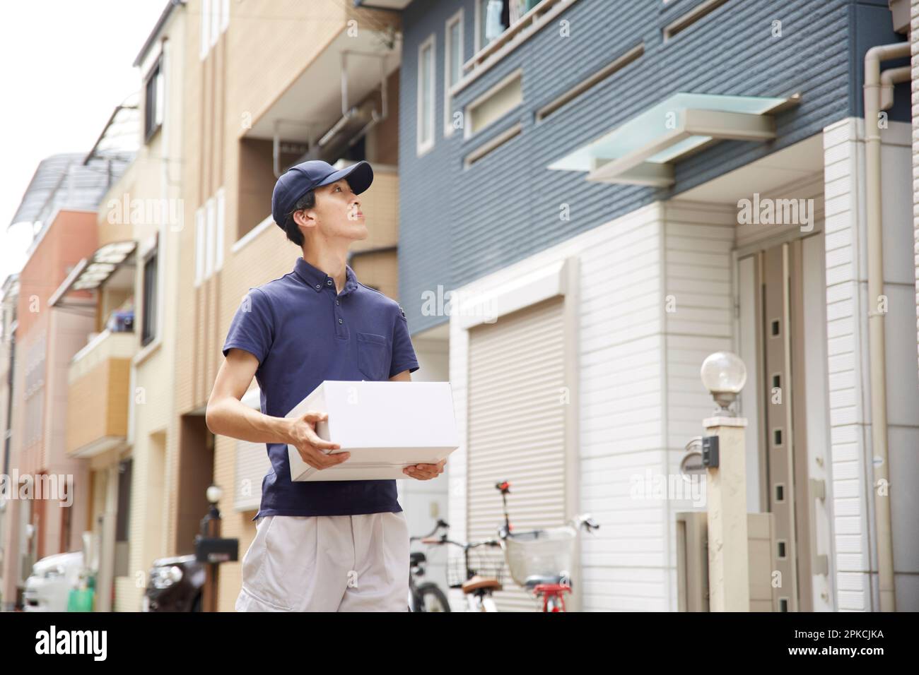 Male delivery man carrying a package Stock Photo - Alamy