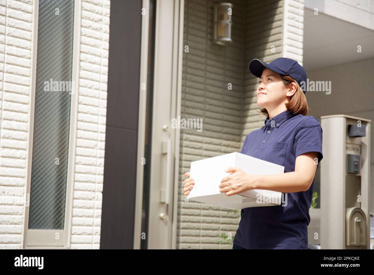 Female courier carrying a package Stock Photo - Alamy
