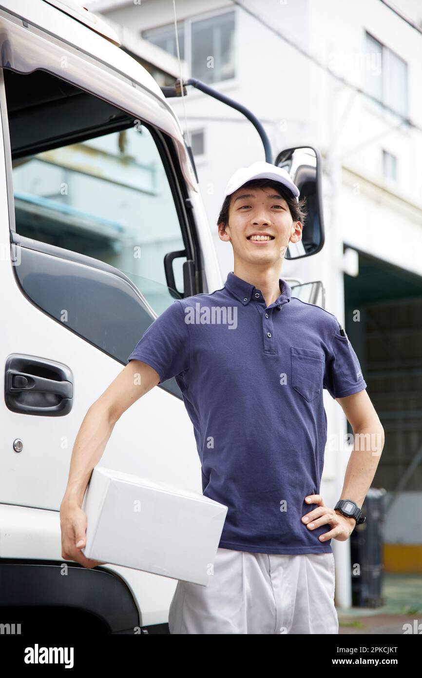 Male courier man standing in front of truck Stock Photo - Alamy