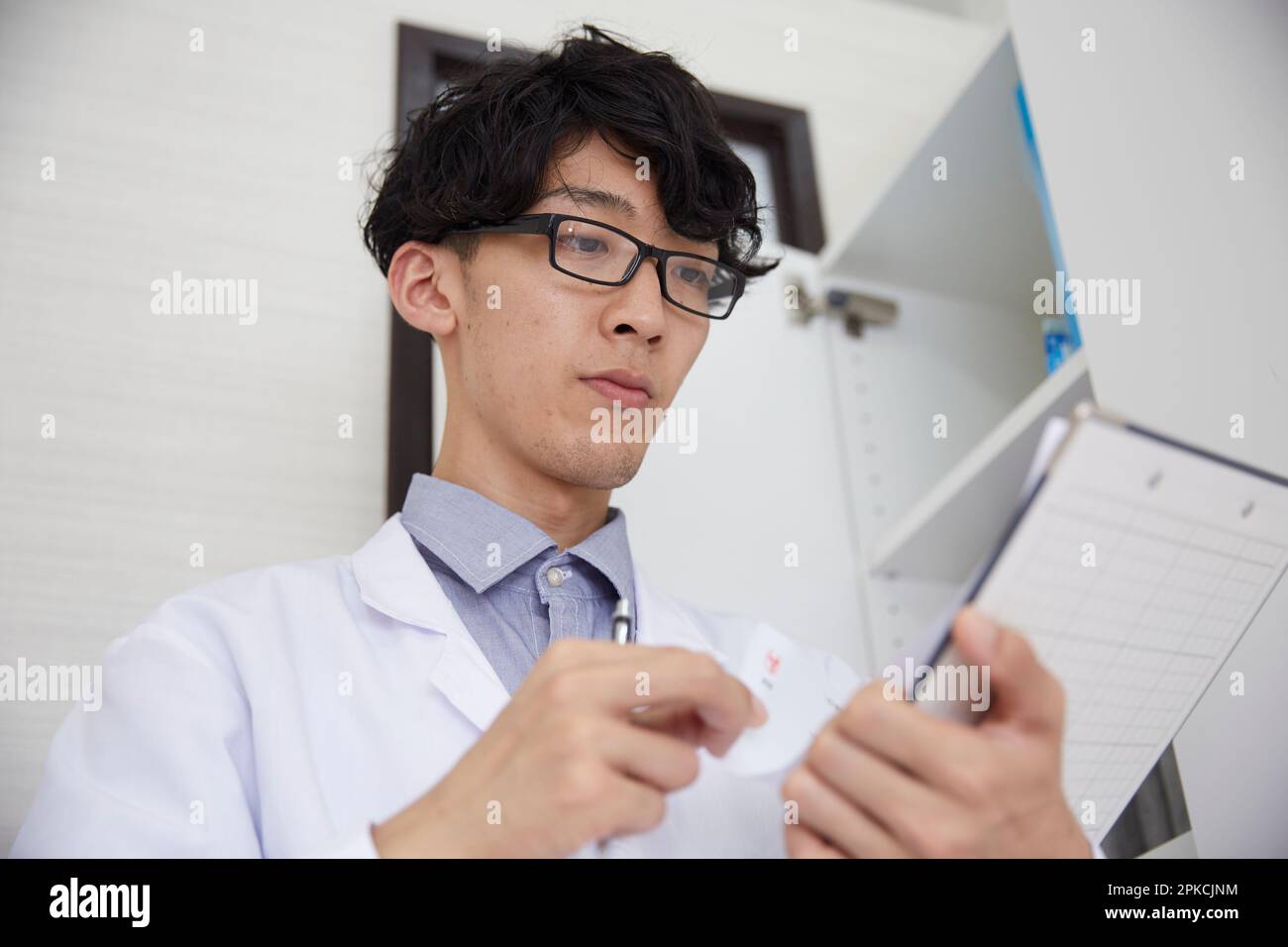 Man in white looking at documents in binder Stock Photo - Alamy