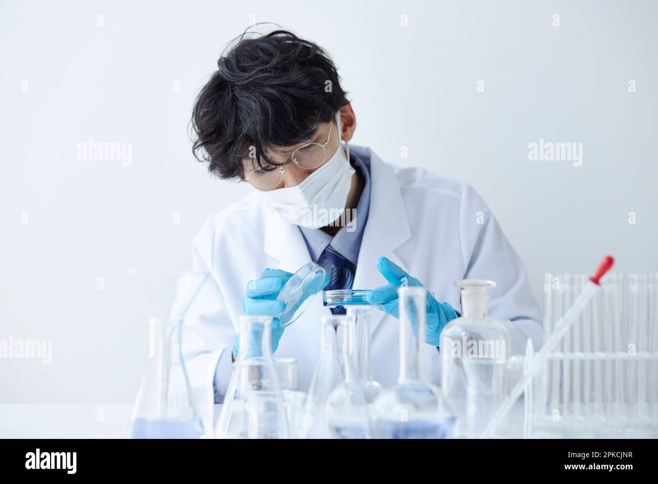 Man in white doing an experiment in a white space Stock Photo - Alamy