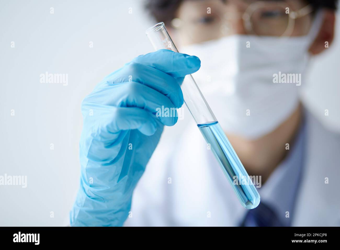 Man wearing white lab coat experimenting in a white space Stock Photo ...