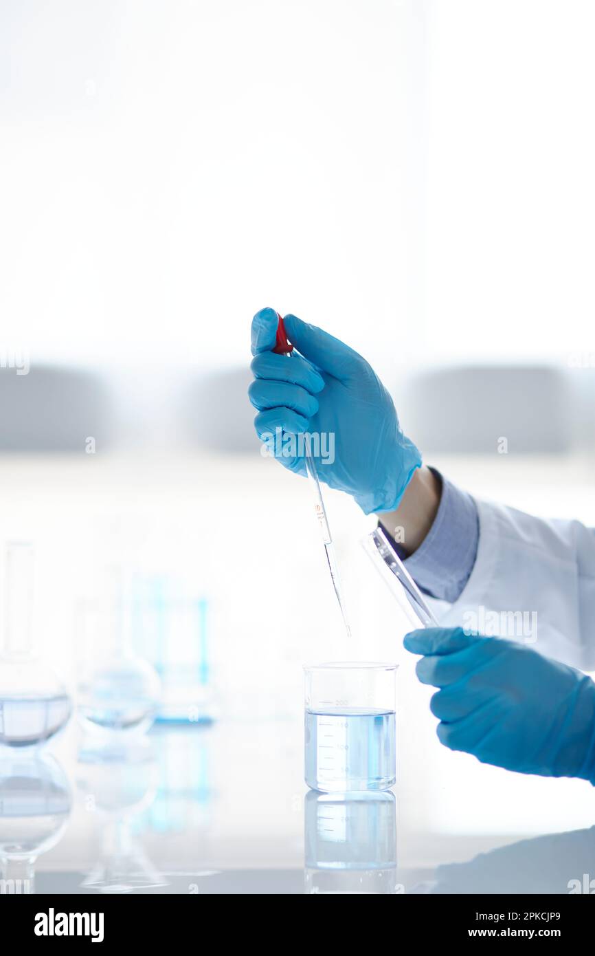 Man wearing white lab coat experimenting in a white space Stock Photo ...