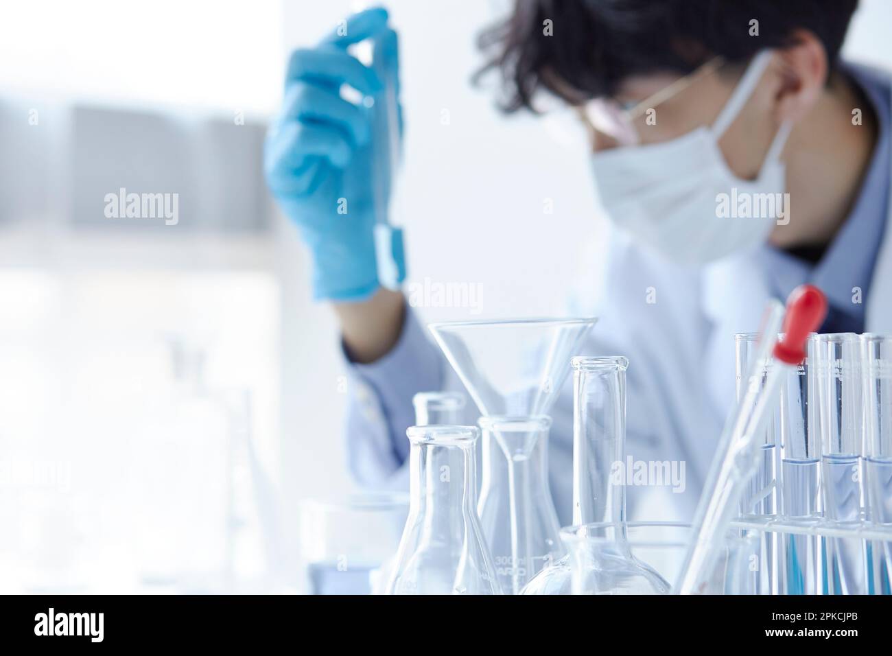 Man wearing white lab coat experimenting in a white space Stock Photo ...