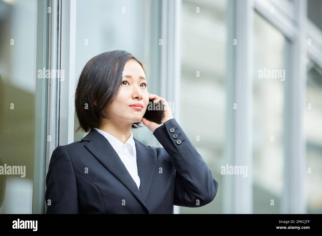 Woman in a recruit suit making a phone call Stock Photo - Alamy