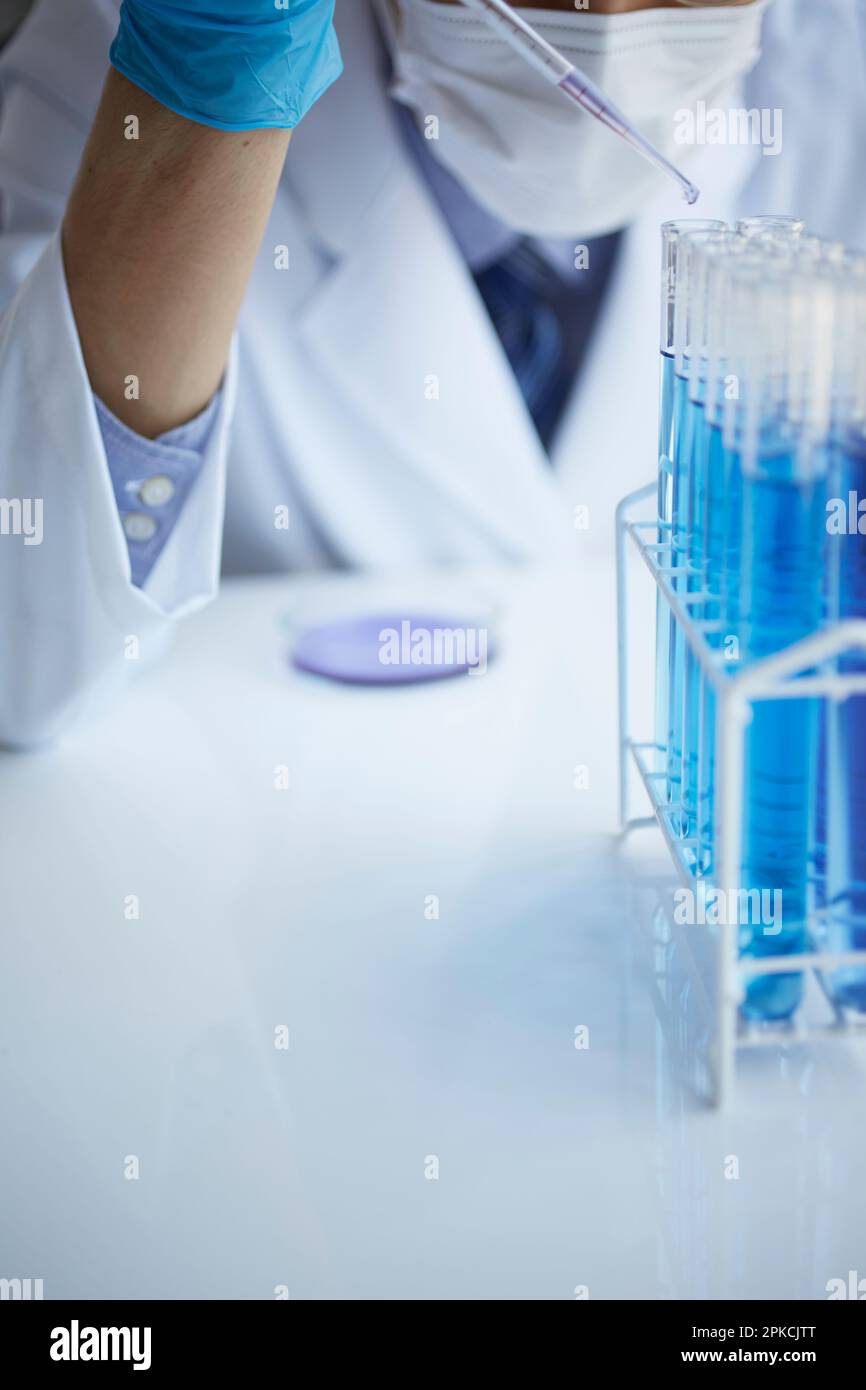 Man wearing white lab coat experimenting in a white space Stock Photo ...
