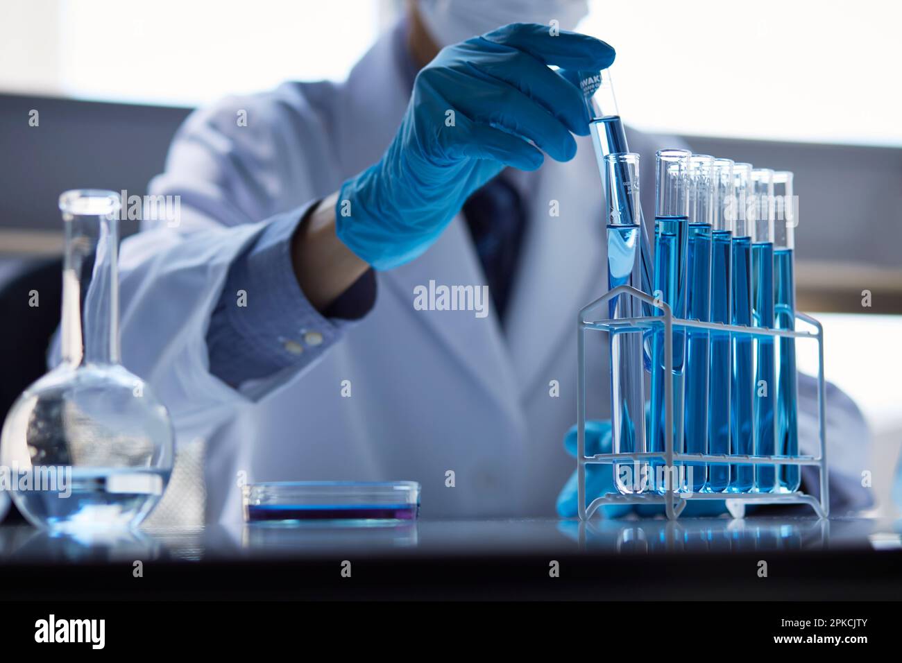 Man wearing white lab coat experimenting in a white space Stock Photo ...