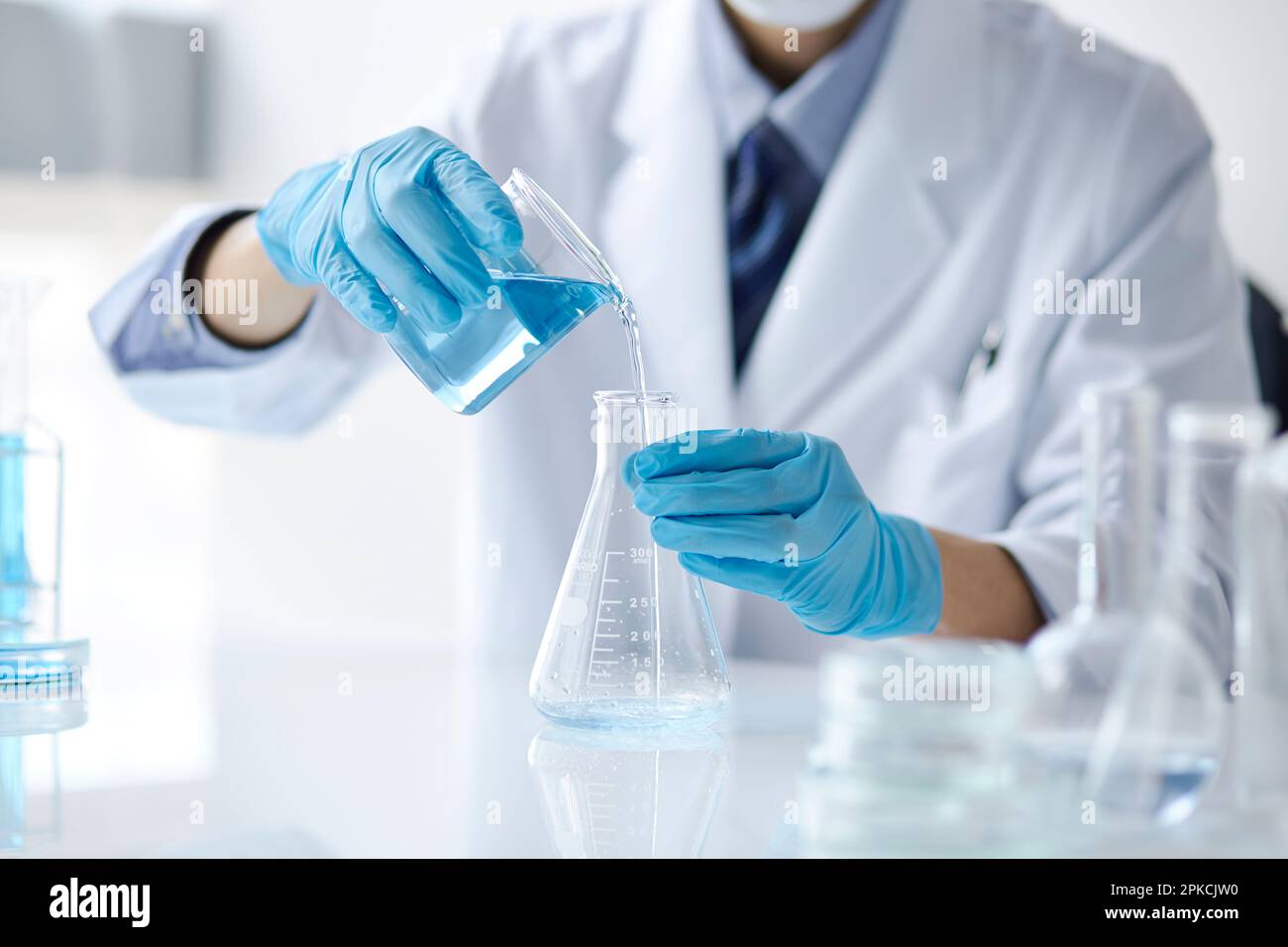 Man wearing white lab coat experimenting in a white space Stock Photo ...