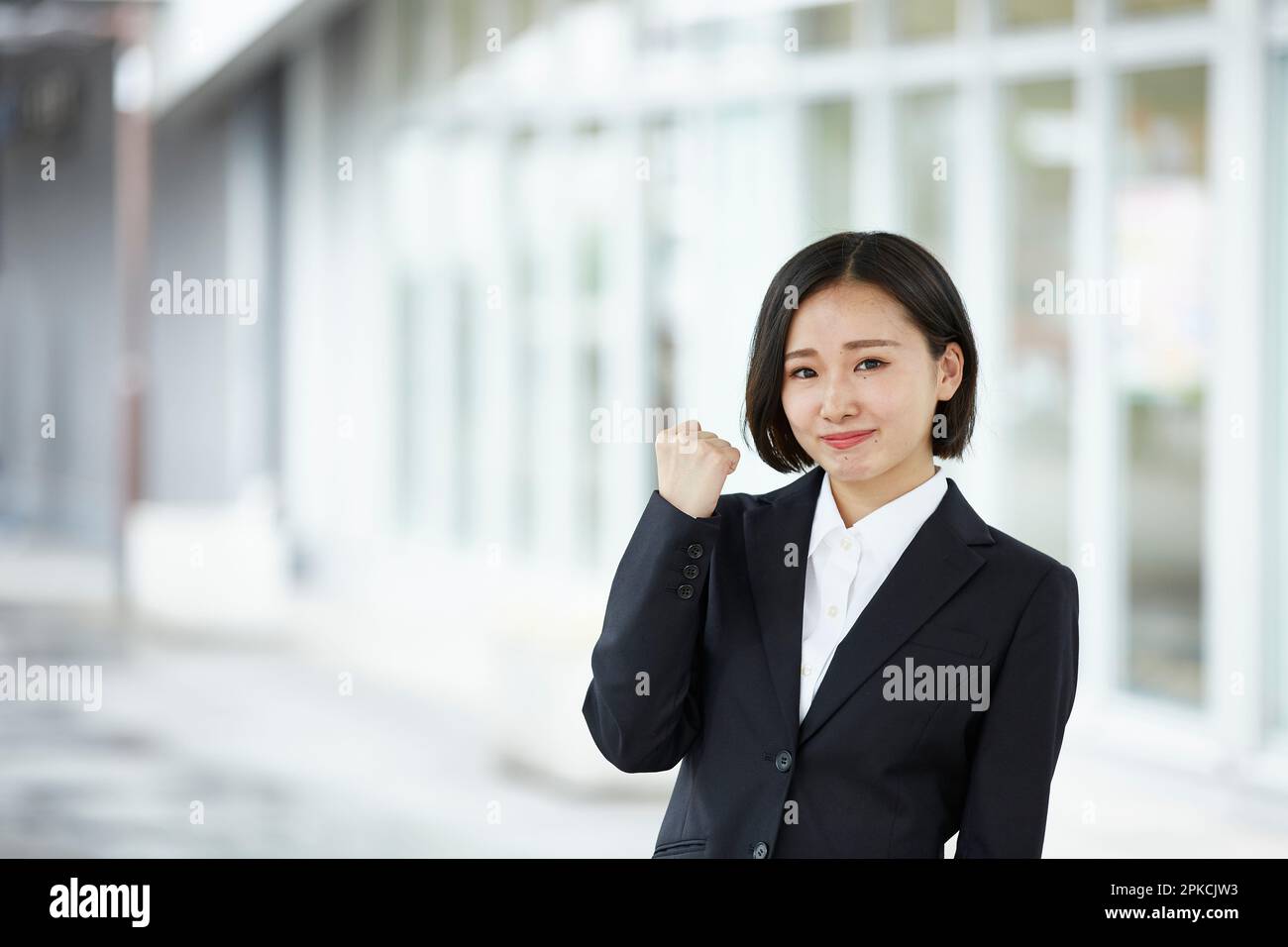 Woman in recruit suit smiling with guts Stock Photo - Alamy