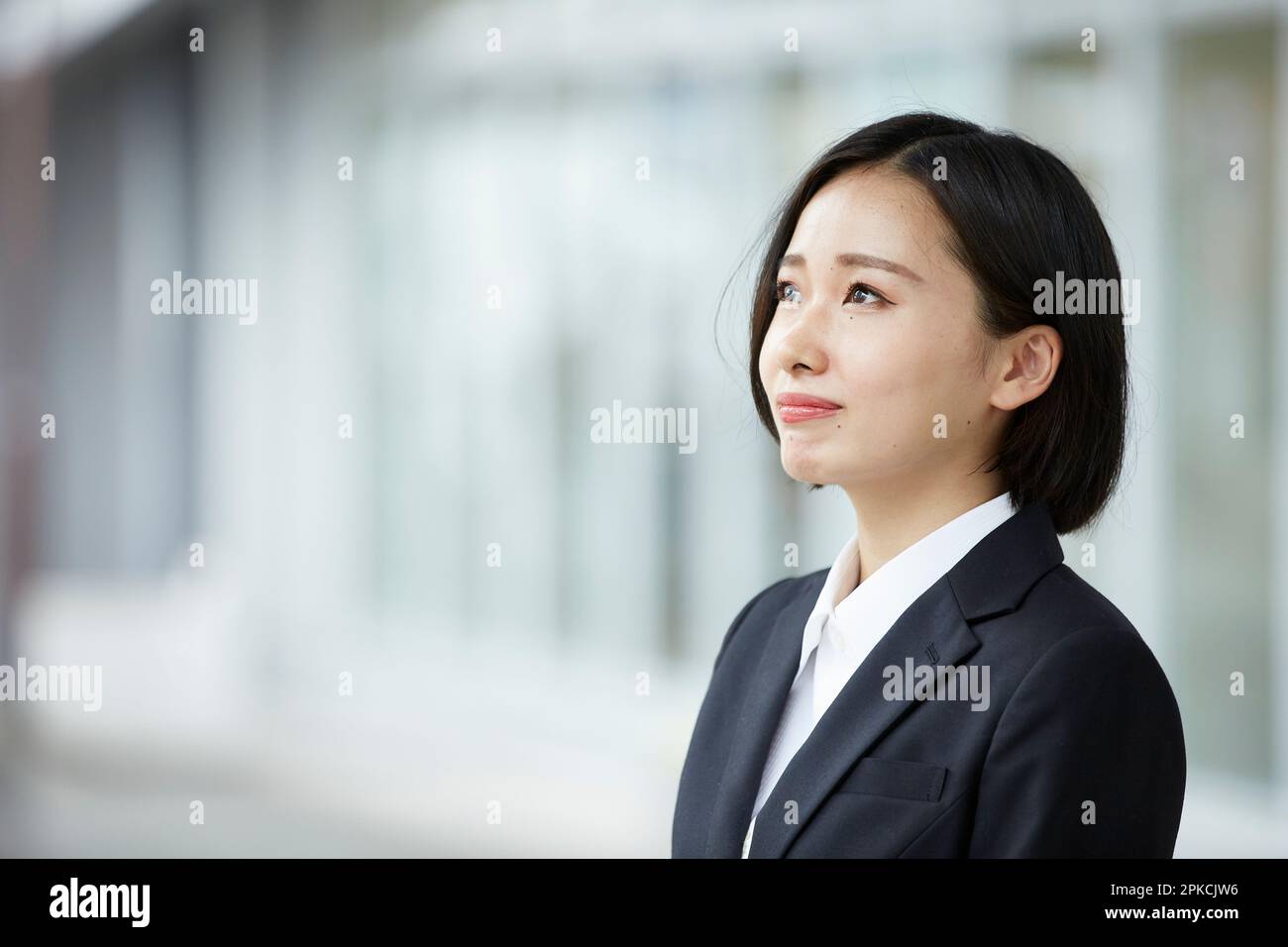Woman smiling in a recruit suit Stock Photo - Alamy