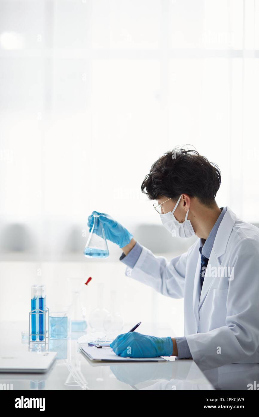 Man in white lab coat experimenting in a white space Stock Photo - Alamy