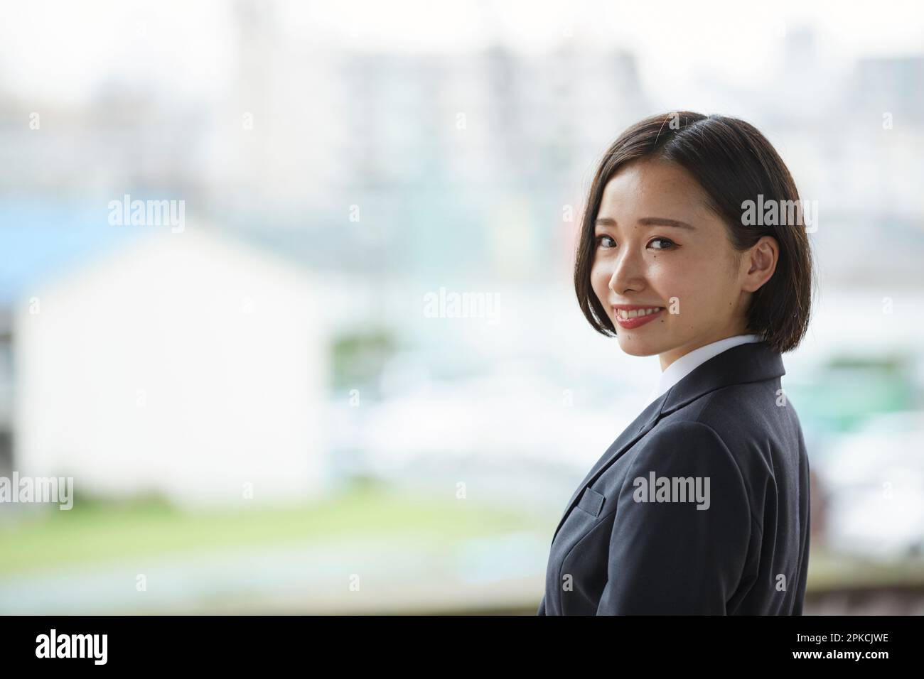 Woman in a suit smiling in a recruit suit Stock Photo - Alamy