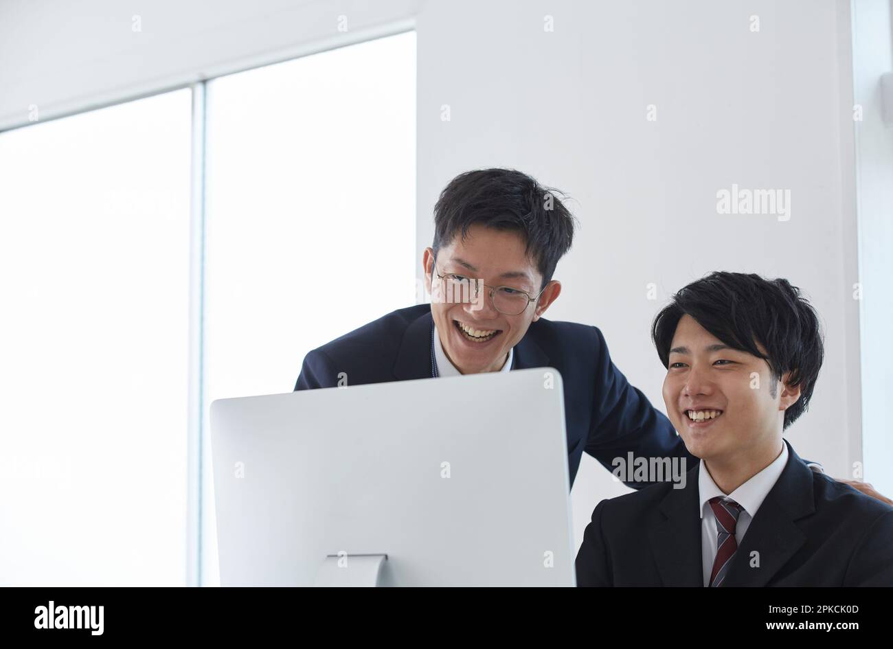 Two businessmen looking at a computer screen Stock Photo - Alamy
