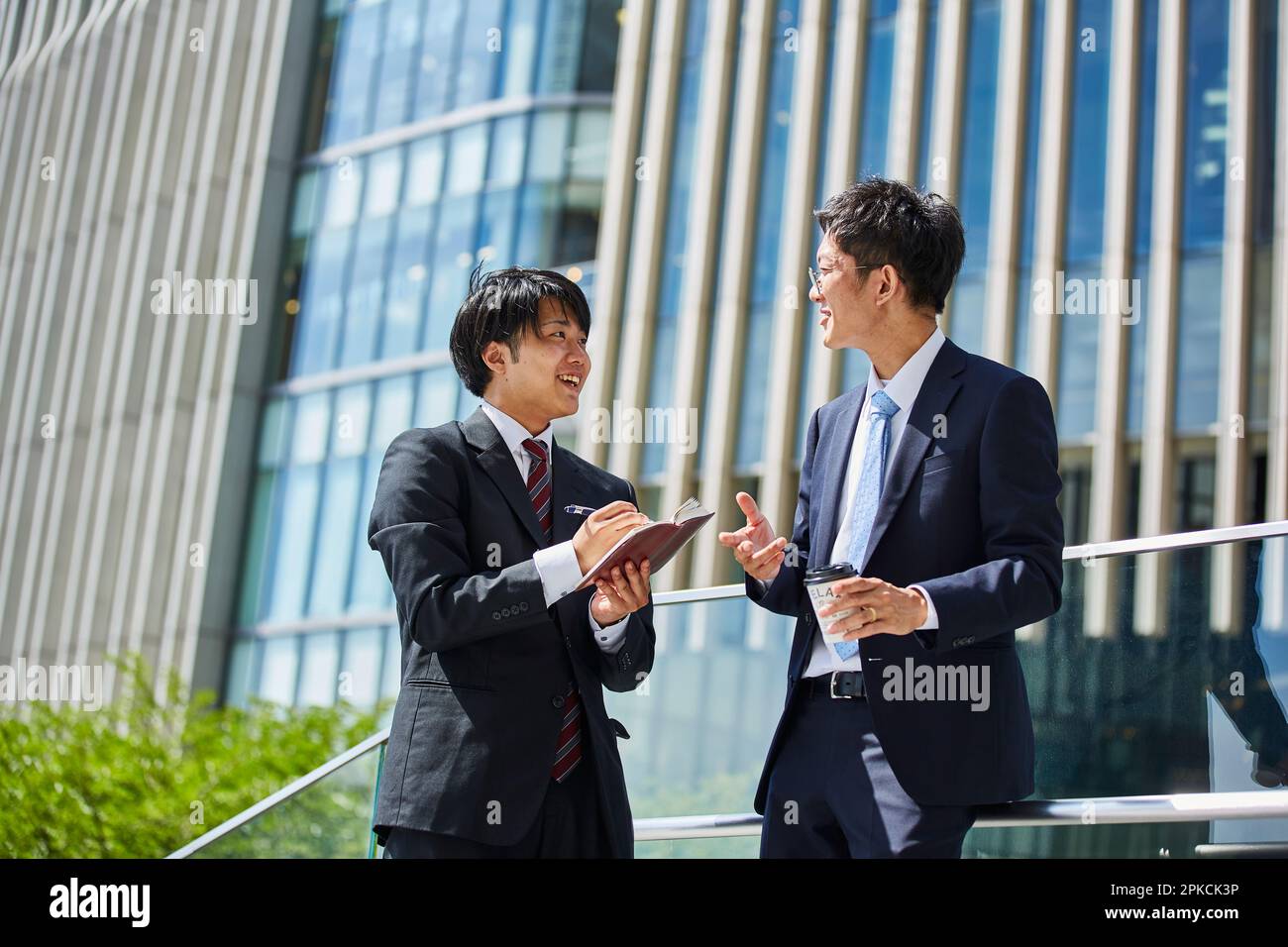 Two men in suits talking outside Stock Photo - Alamy