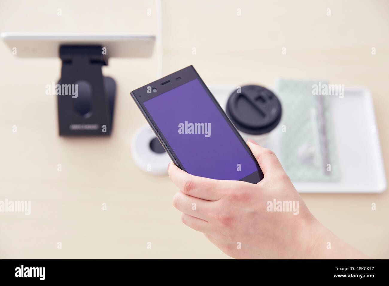 Holding a smartphone over a cashless payment terminal Stock Photo - Alamy