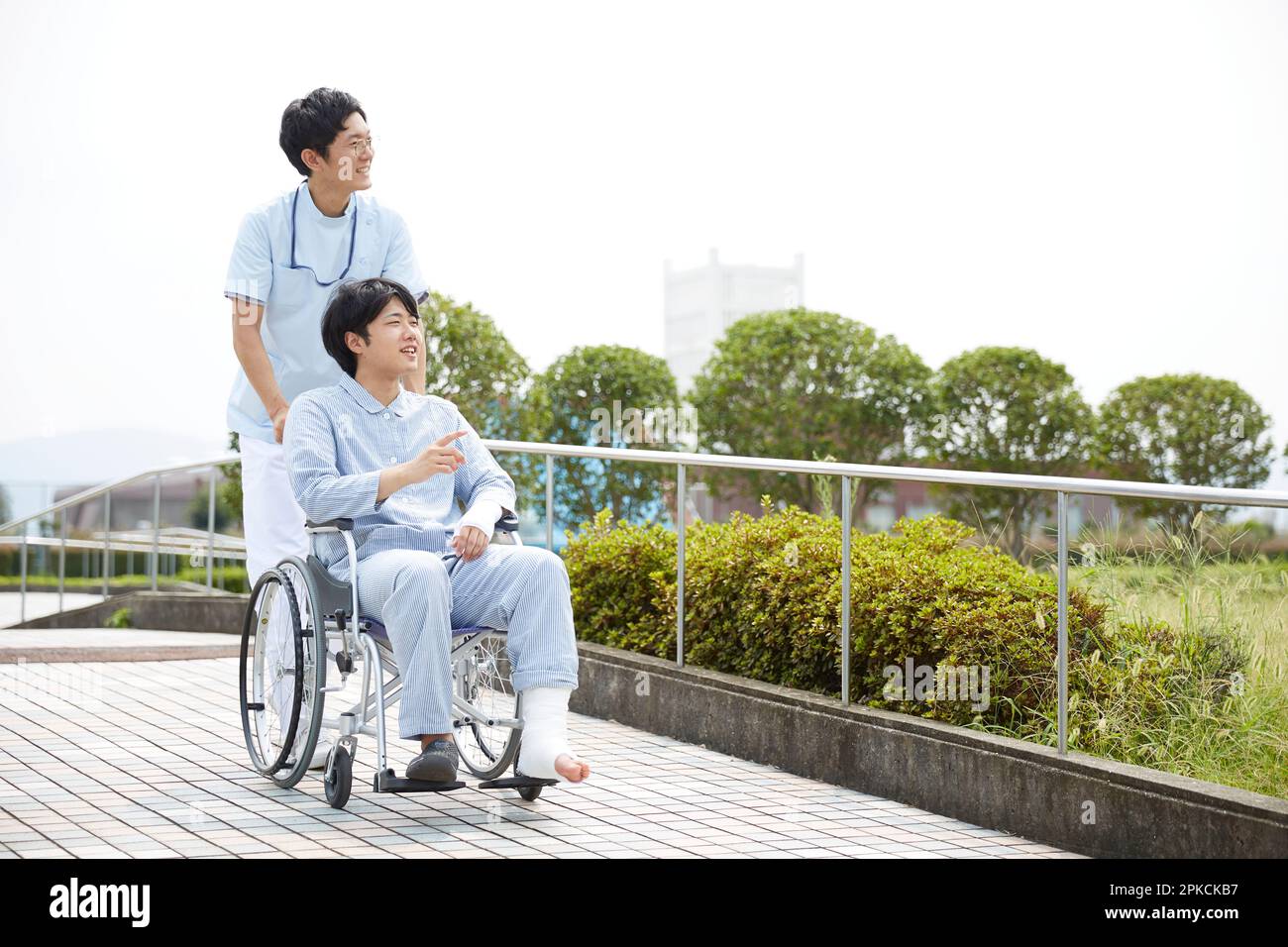 Patient and nurse with wheelchair walking Stock Photo - Alamy